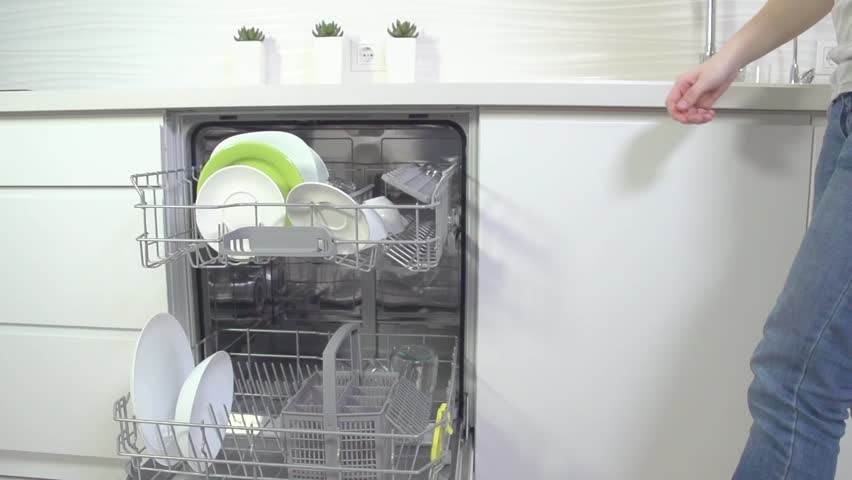 Dishwasher. Happy Young Woman In The Kitchen Doing Housework ...