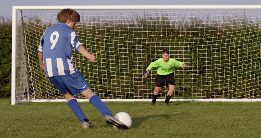 Soccer Player Kicking Ball Into Goal