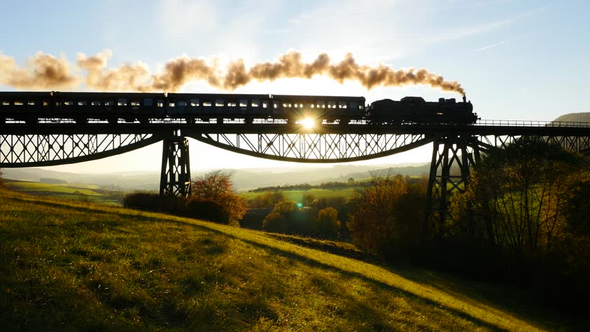 Silhouette Of Steam Engine Train Crossing Bridge. Romantic Sunset ...