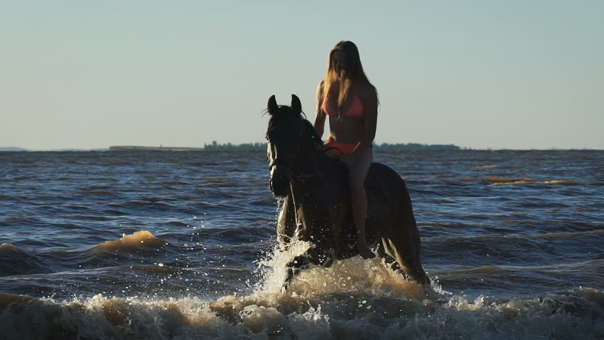 A Sexy Young Beautiful Sexy Blonde Woman In Bikini In The Sea Riding A ...