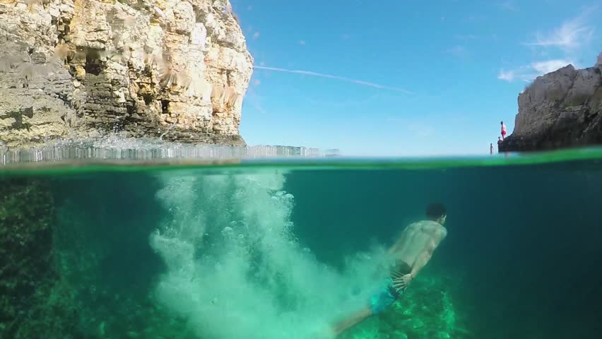 HALF UNDERWATER SLOW MOTION CLOSE UP: Happy Young Man Jumping Headfirst ...