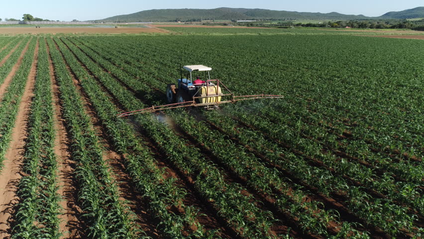 Aerial View Following A Tractor Spraying Large Scale Farming Vegetable ...