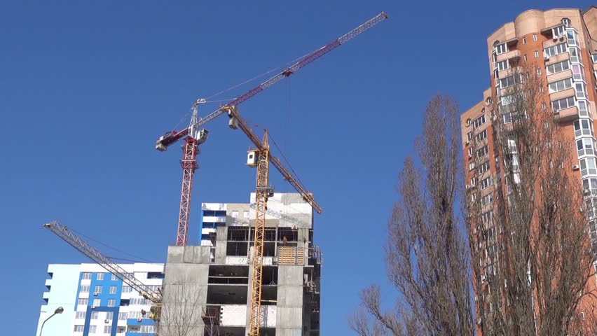Construction Of New Houses Against The Blue Sky. The City Is Building ...