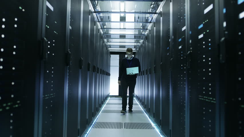 People Working In Computer Server Room Data Center. Walking Along Rows ...