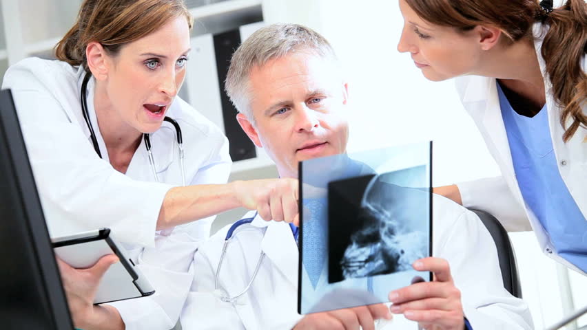 Caucasian Male Medical Consultant With Young Female Doctor Updating ...