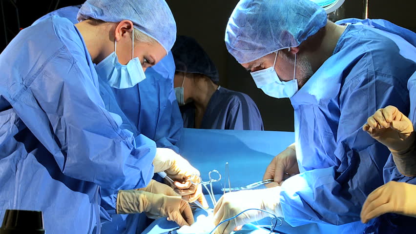 Senior Doctor Performing Operation Using Surgical Equipment Helped By ...
