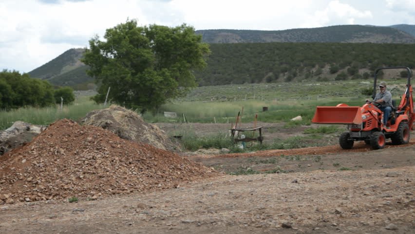 Stock video of small orange tractor backhoe driving and | 431860 ...