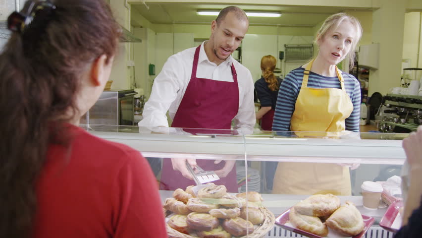 Friendly Staff Serving Customers With A Smile At The Bakery Counter ...