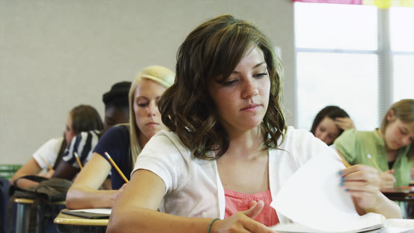 View From Behind Pupils As Teacher Helps Individual Member Of Class ...