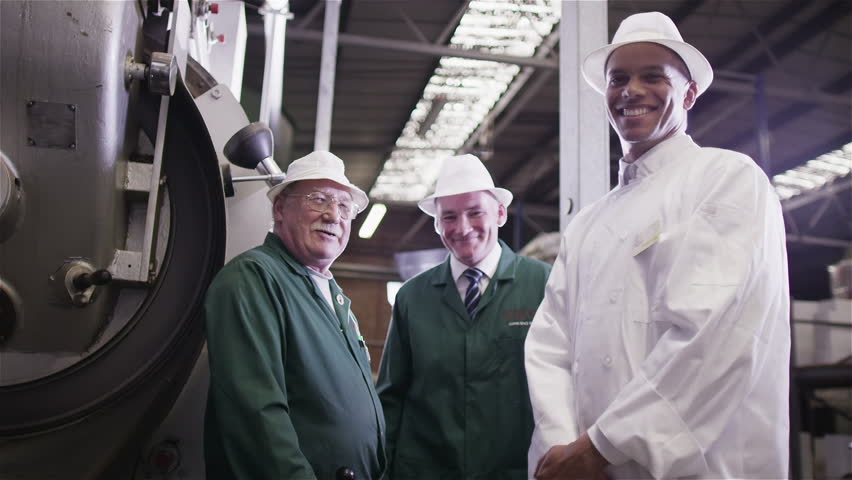 4K Production Facility Team Staff Together On Factory Floor. Smiling ...